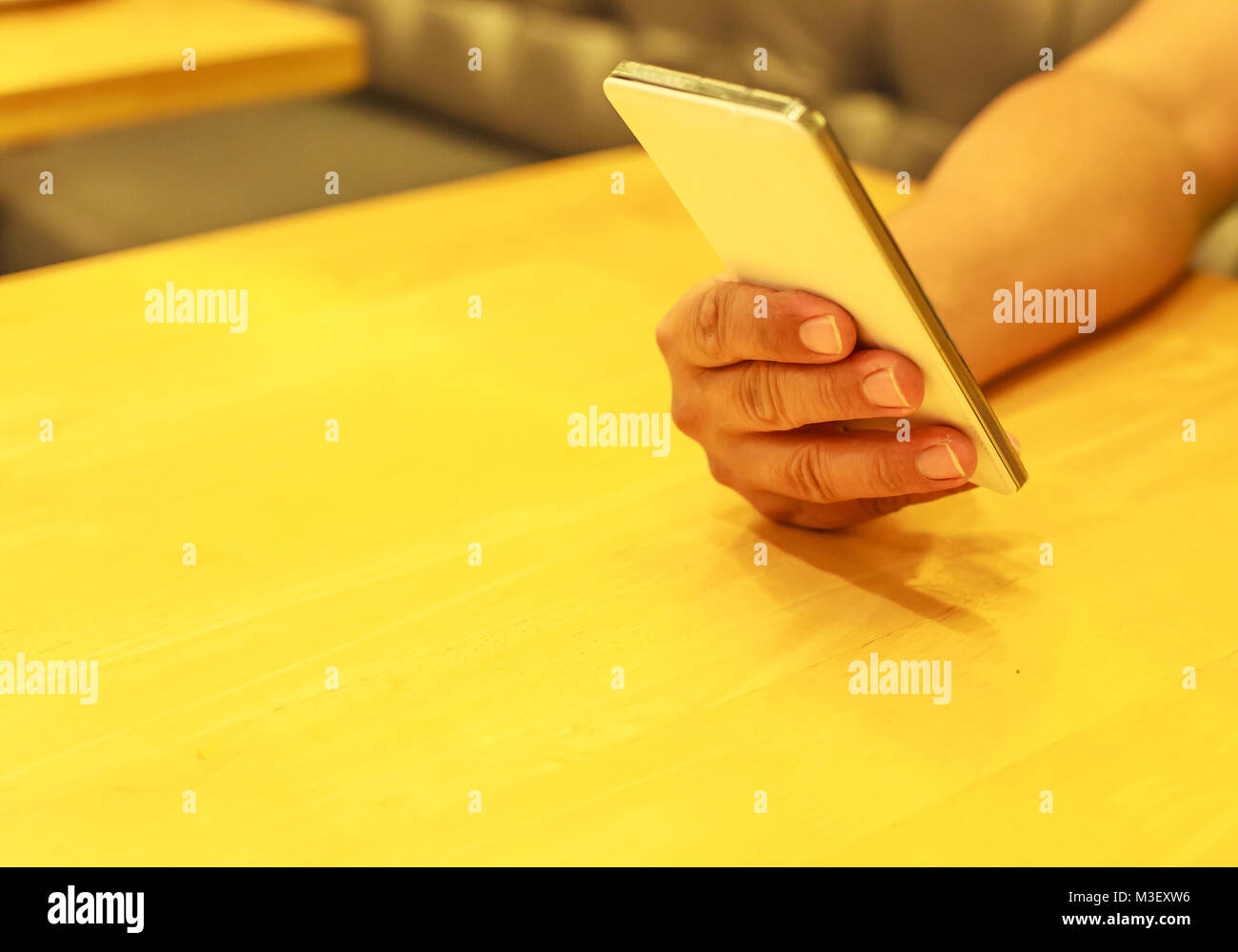 Man Hand, using smart mobile phone on the table indoor Stock Photo - Alamy