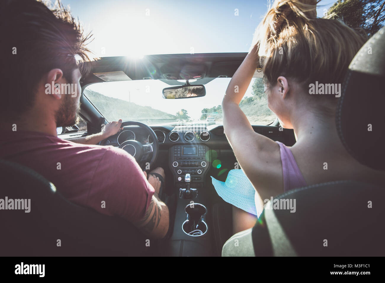 Couple driving on a convertible car Stock Photo - Alamy