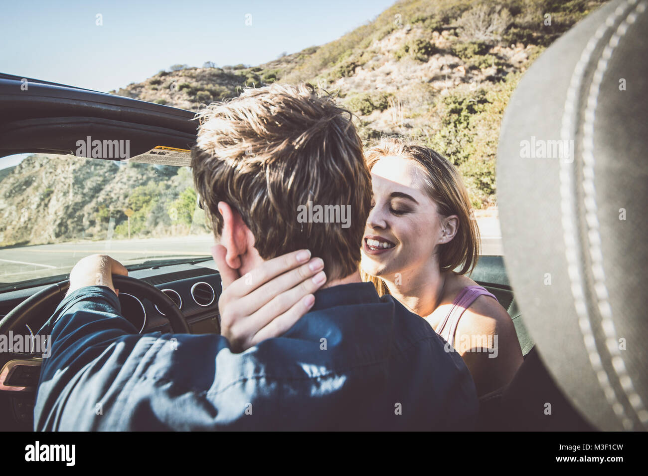 Couple driving on a convertible car Stock Photo - Alamy