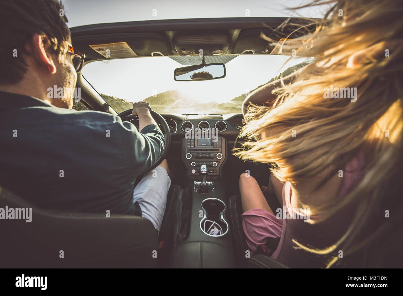 Couple driving on a convertible car Stock Photo - Alamy