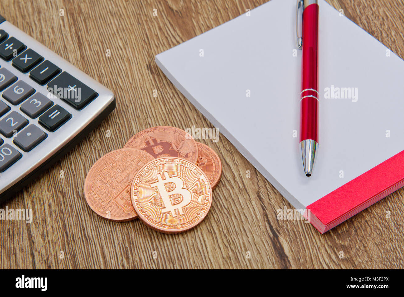 Bitcoins, calculator and notes on a wooden table Stock Photo - Alamy