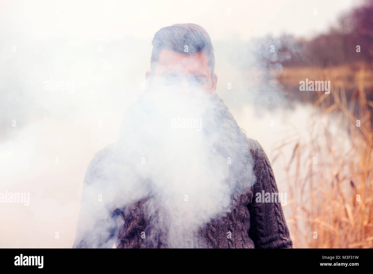 portrait of man hiding in the fog in front of lake Stock Photo - Alamy