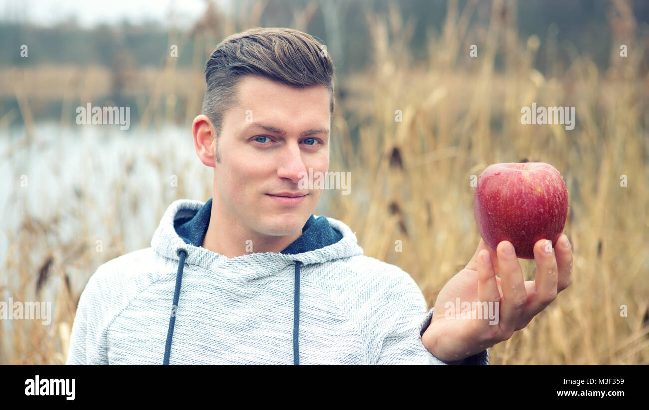 portrait of handsome man outdoors with an apple in his hand Stock Photo ...