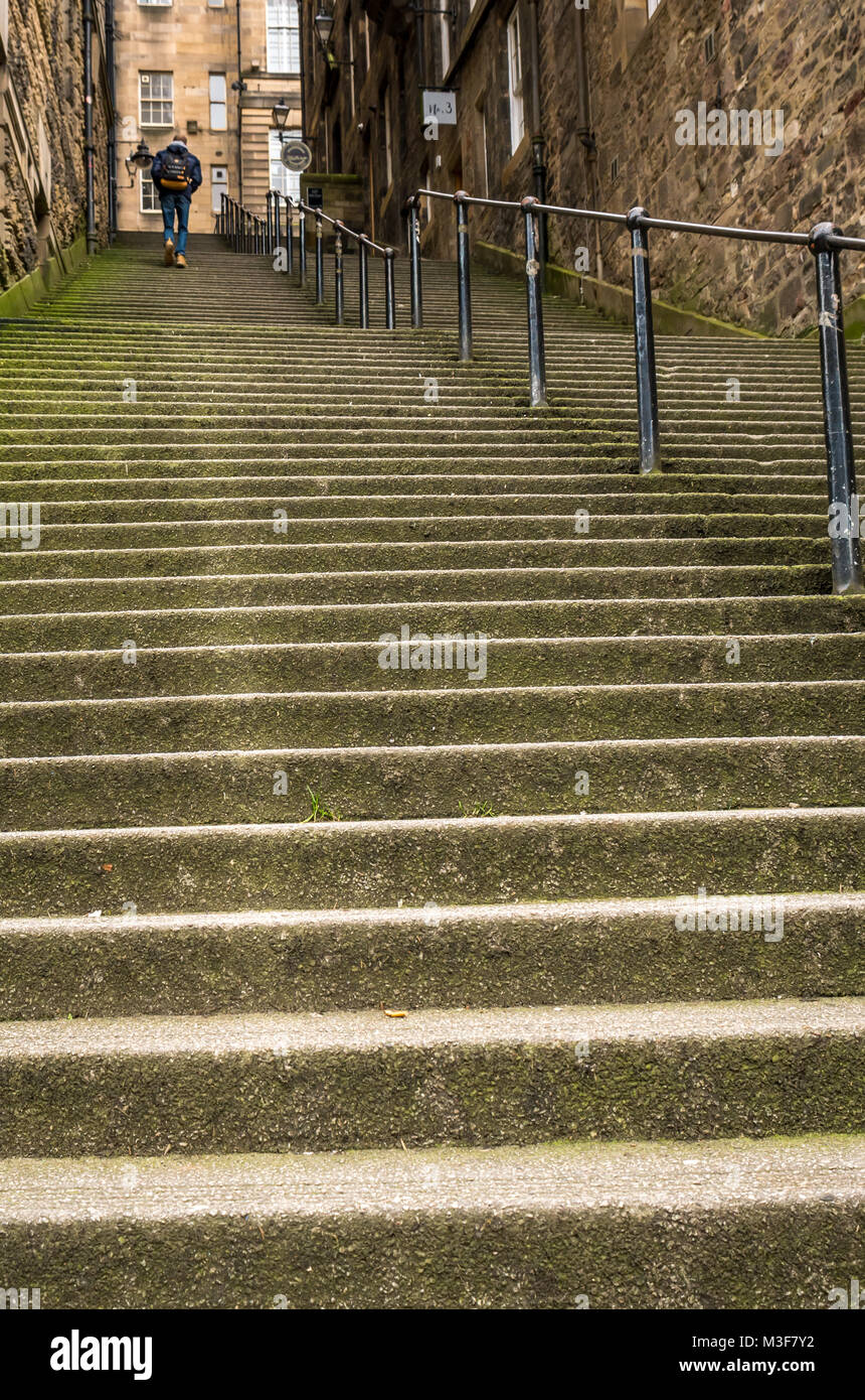 Man walking up steep stone steps in an alley or narrow passage ...
