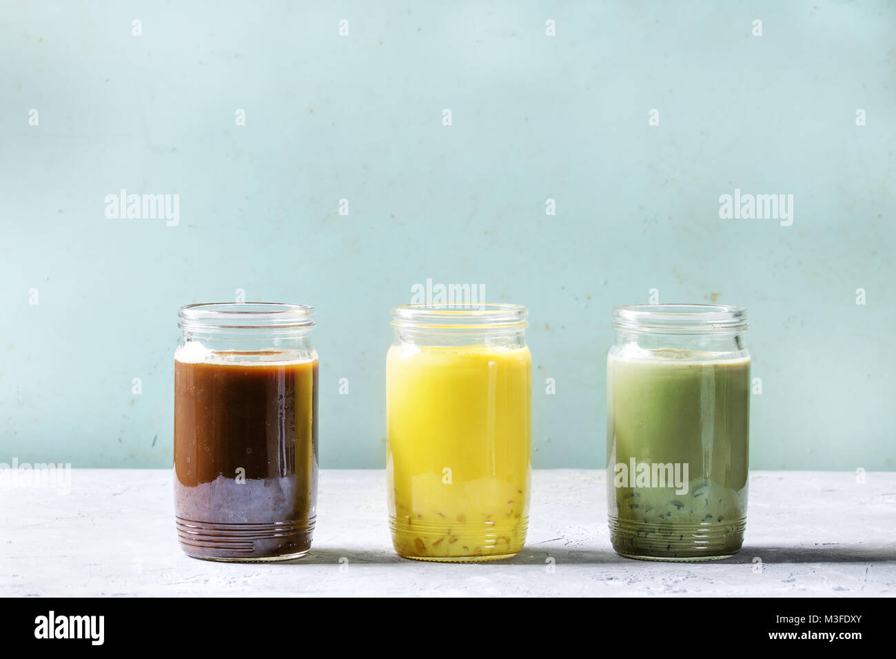 Variety of iced colorful latte drinks. Iced coffee, turmeric and matcha ...