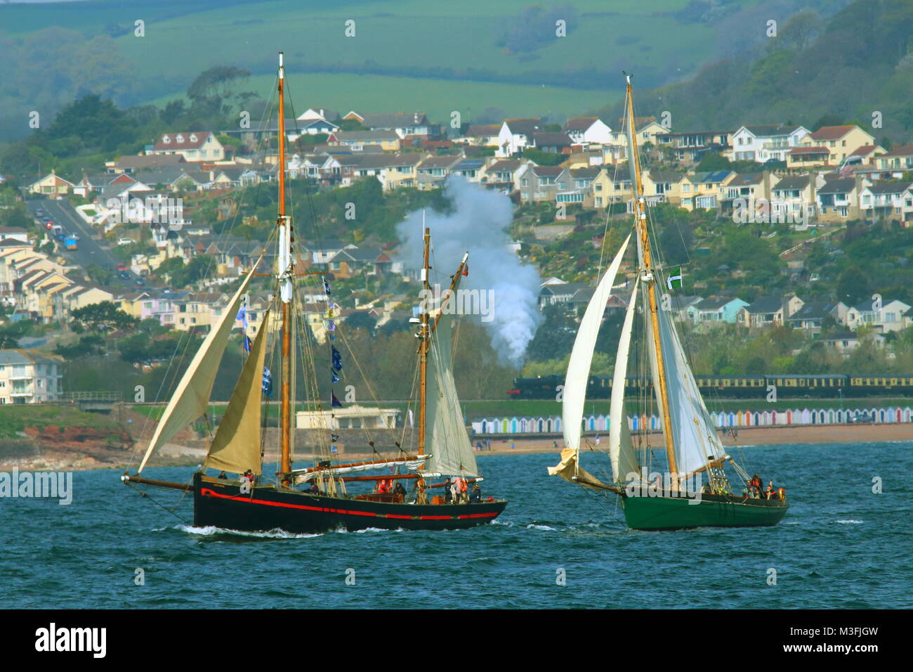 Traditionally rigged sailing vessels racing in Torbay as a steam train ...