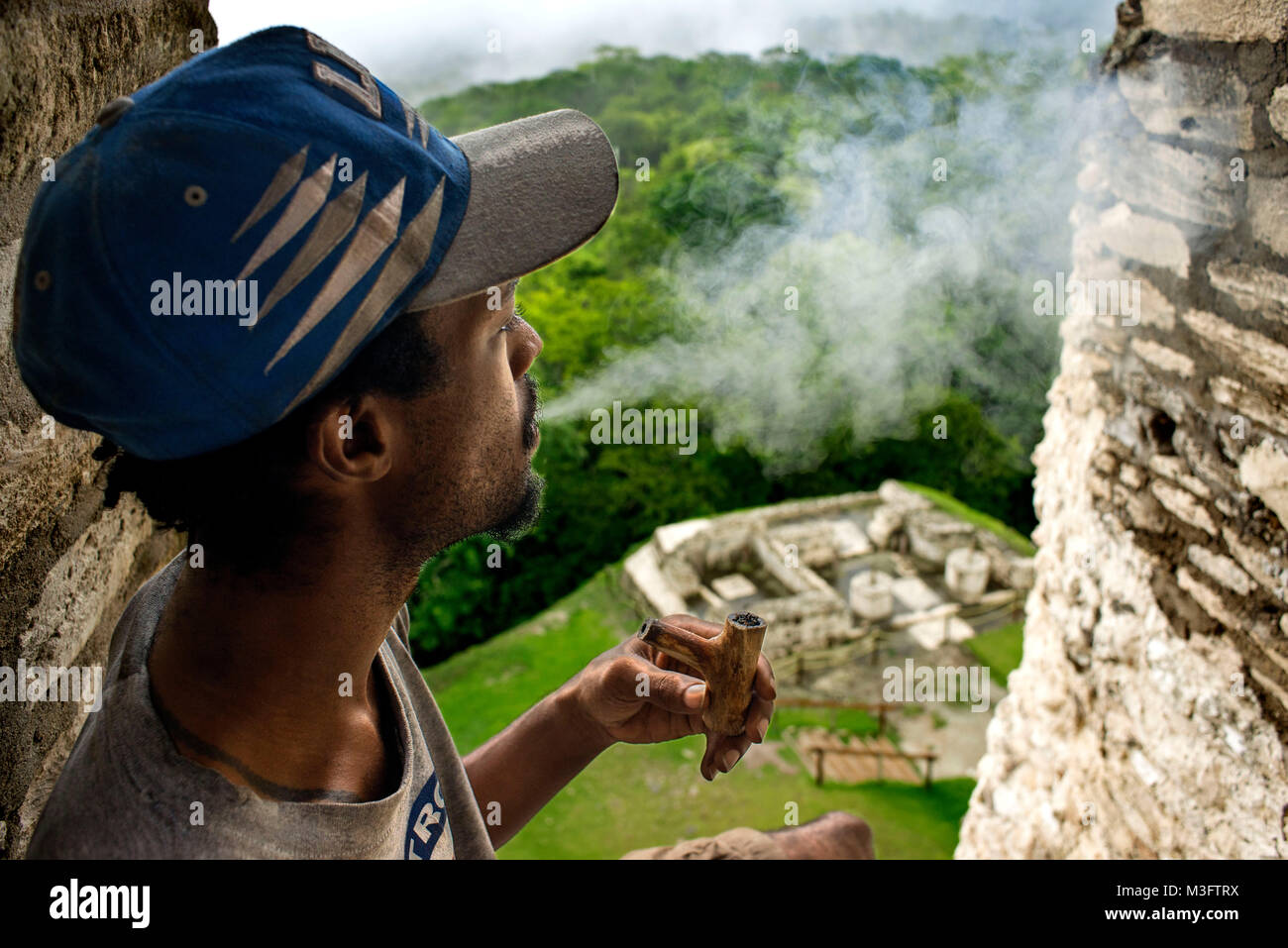Local people smoking in pipe in Mayan ruins of Xunantunich ...
