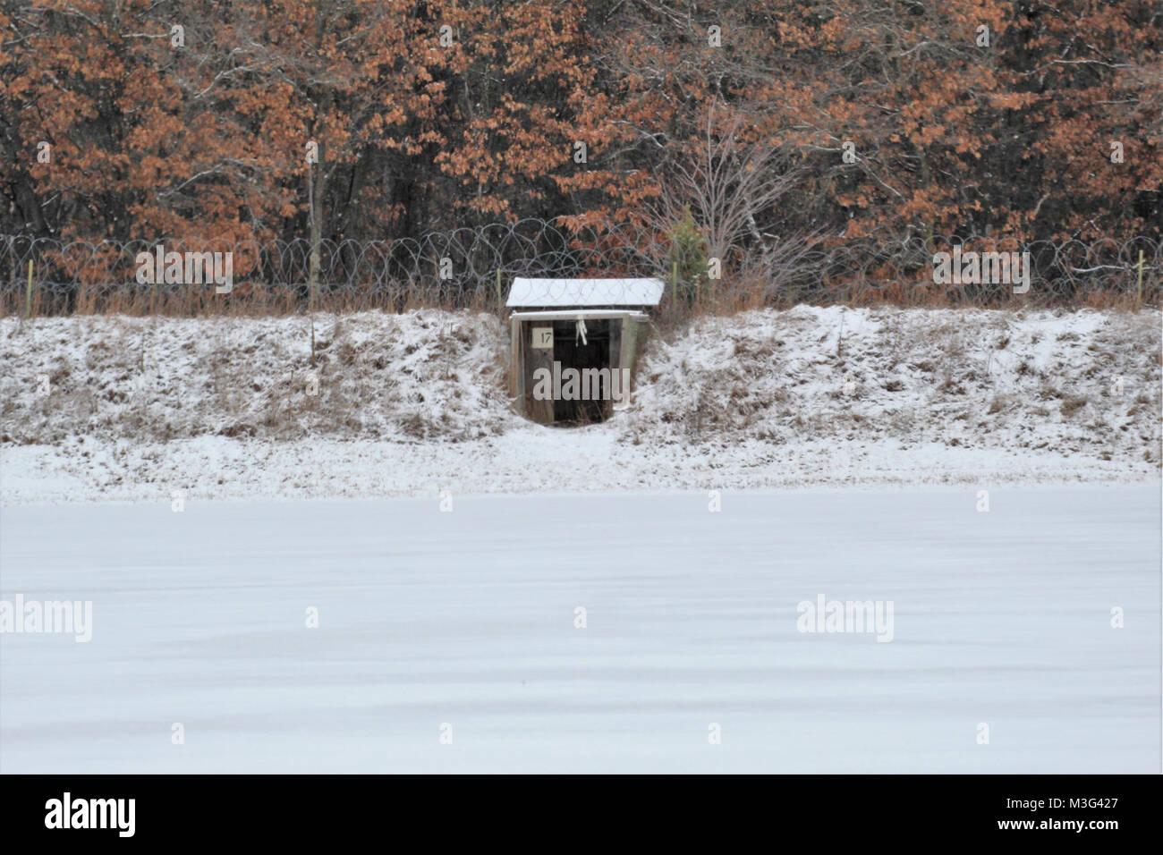 A training area defensive fighting position is shown covered in snow at ...