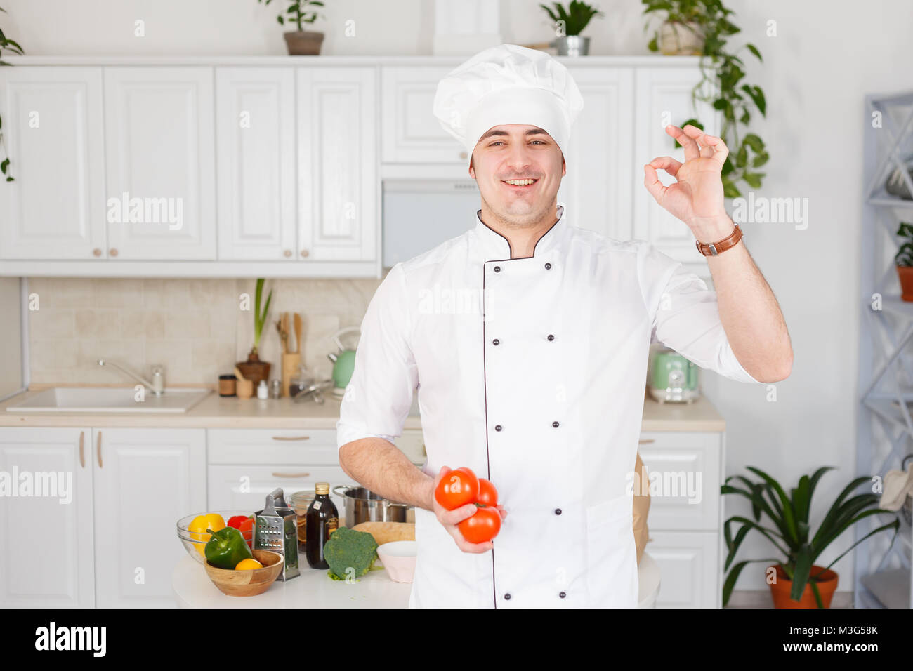Chef with tomato in hand gesture ok Stock Photo - Alamy