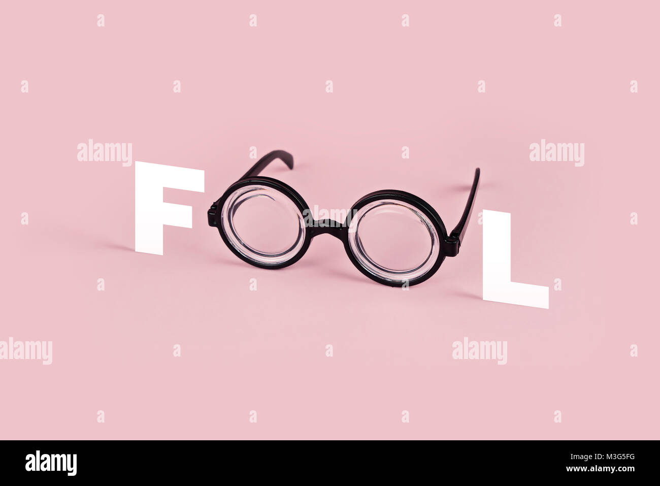 Funny goggles with round glasses on pink background and the word FOOL ...