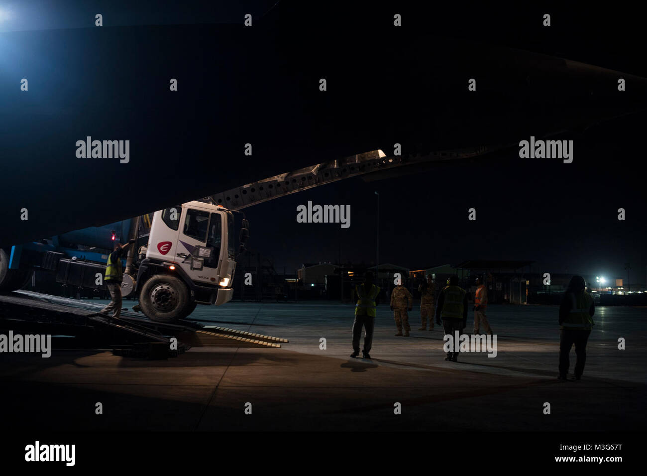 U.S. Air Force loadmasters and aerial transport team members unload a ...
