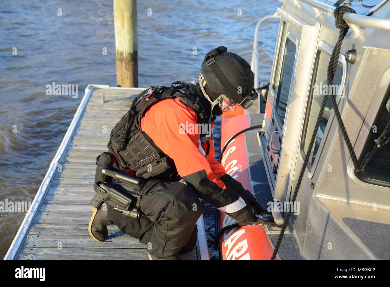 A Coast Guard Maritime Safety and Security Team member ties up his ...