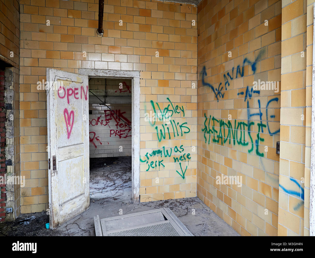 Interior of abandoned building with graffiti painted on the tile walls ...