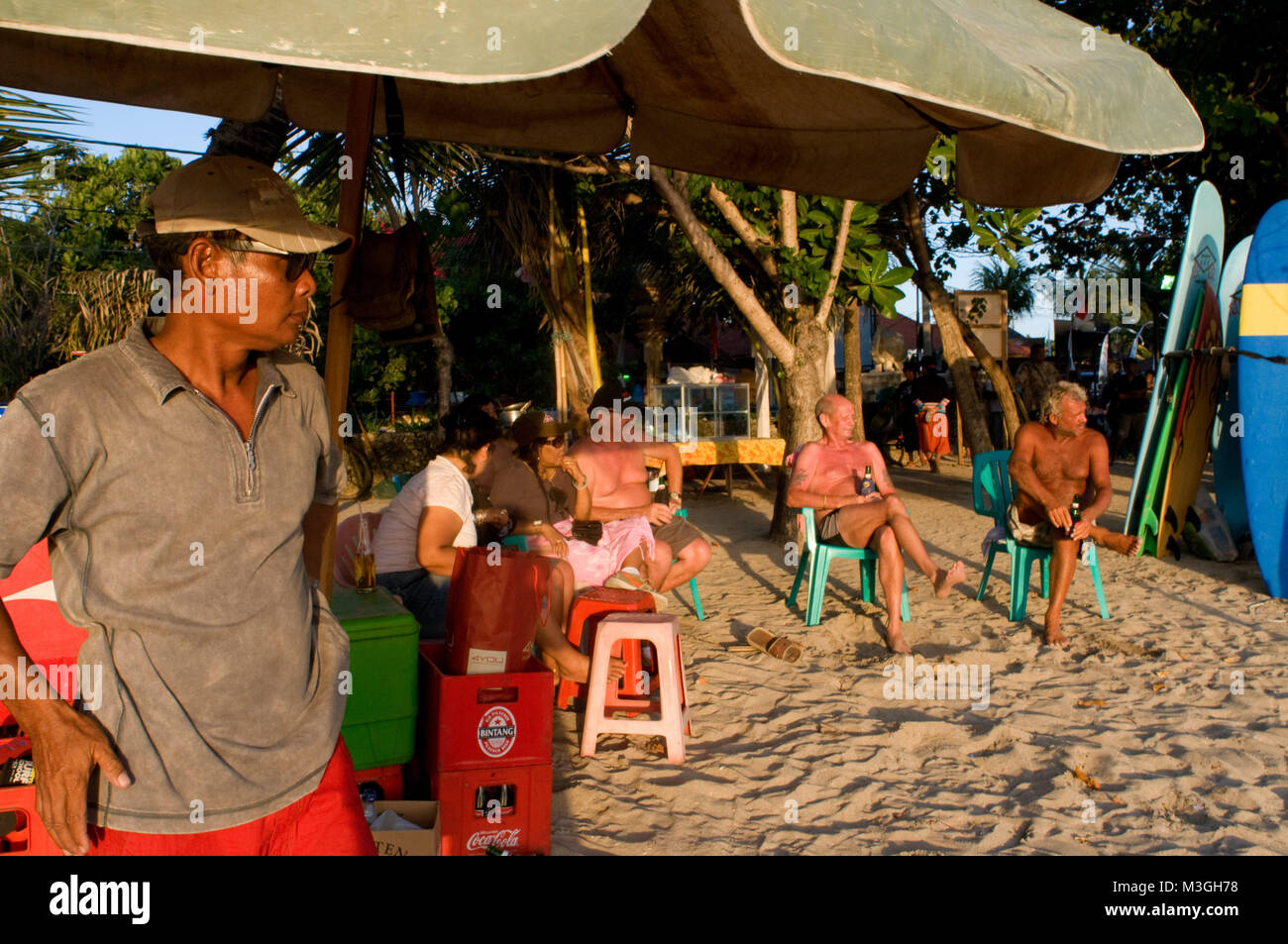 A crowd of tourists and backpackers enjoy the sunset in a beach bar in ...