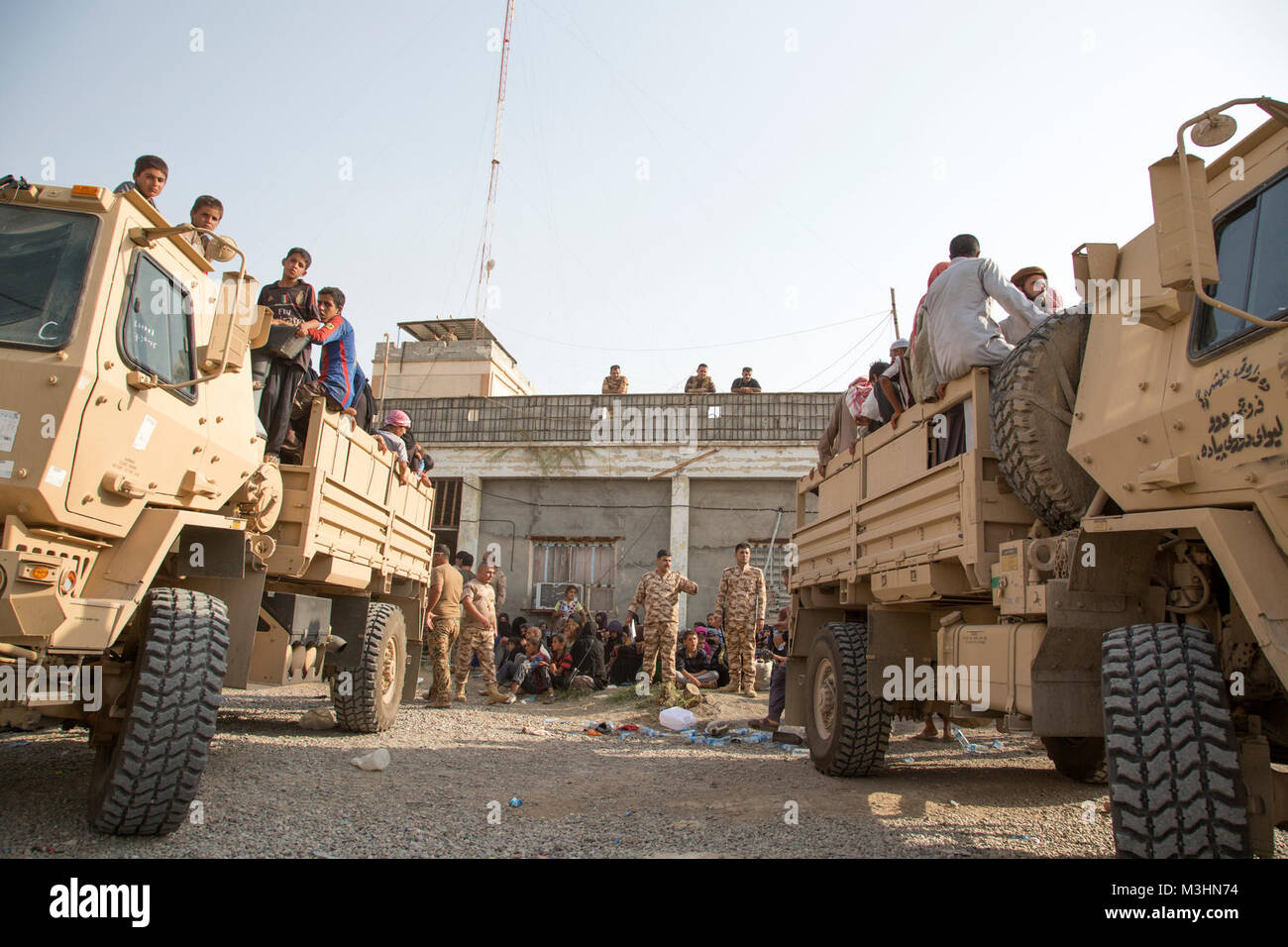 Internally displaced persons arrive at a screening point in Dibis, Iraq ...
