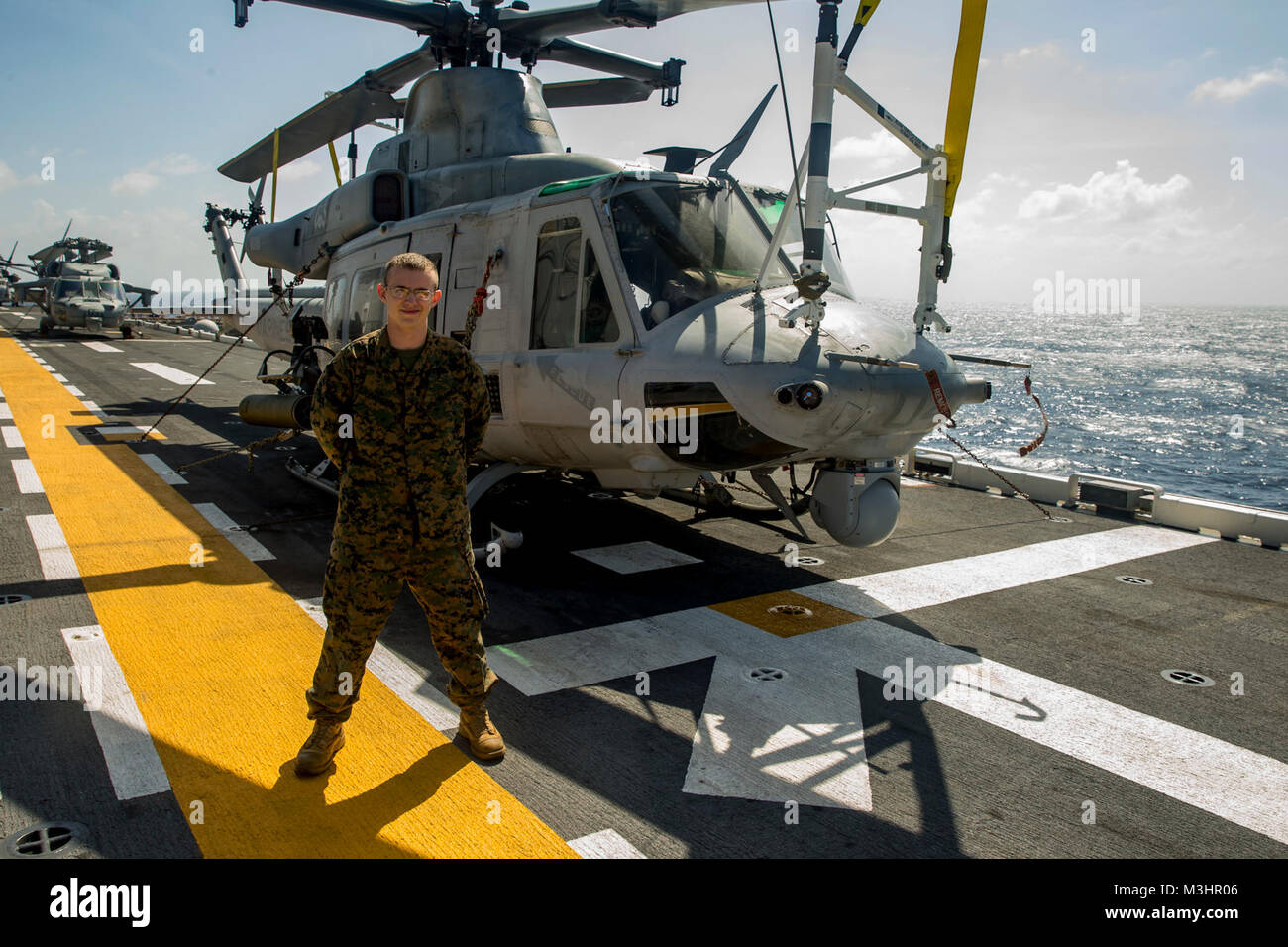 U.S. Marine Lance Cpl. Jerimiah Cunningham stands in front of a UH-1Y ...