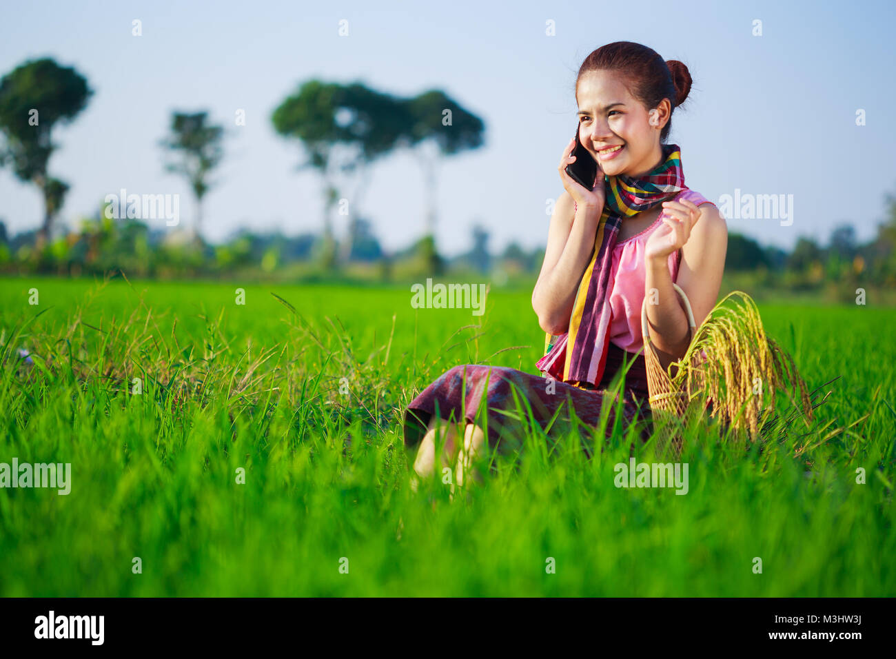 farmer woman calling on the mobile phone in a rice field, Thailand ...