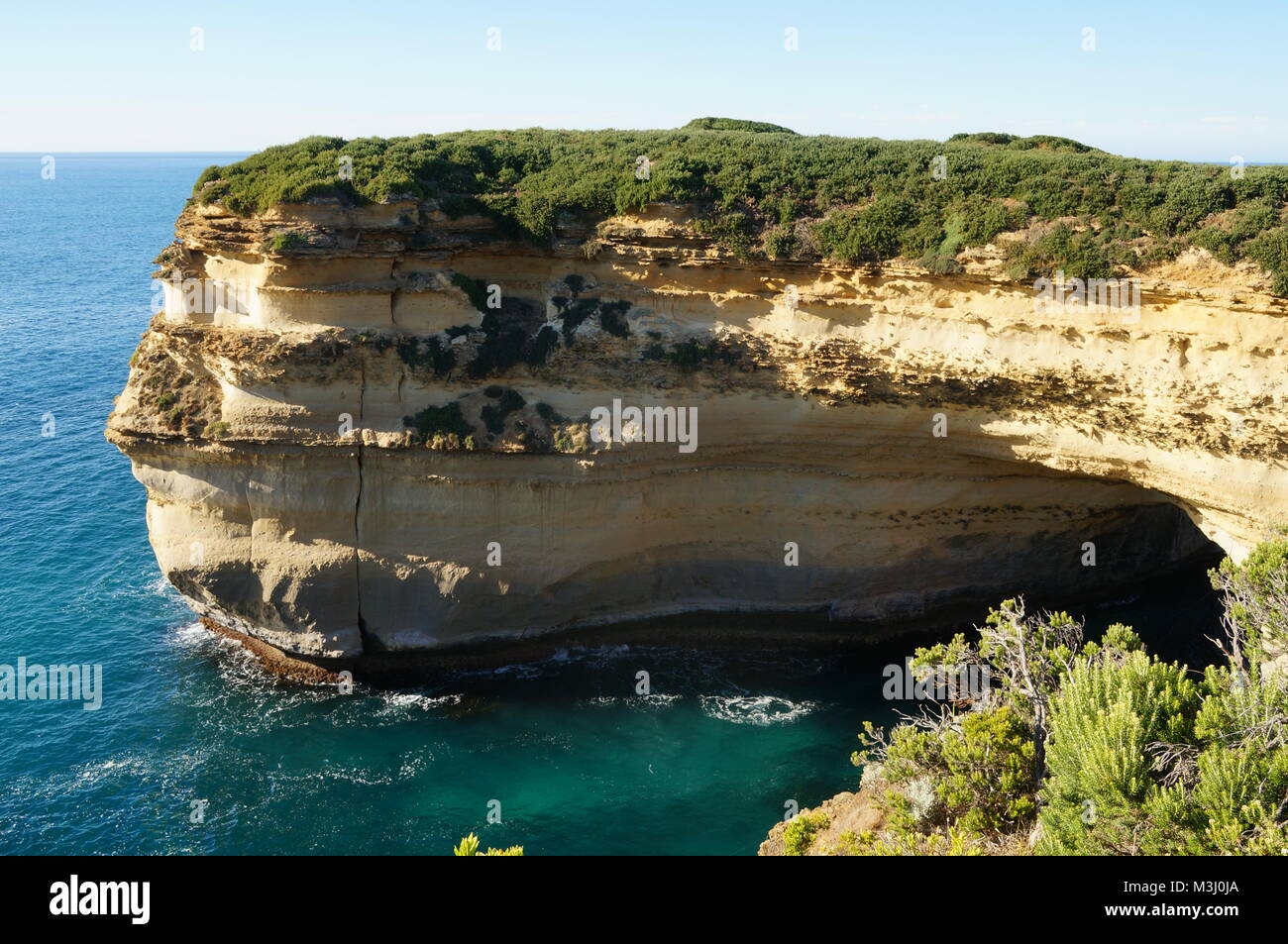 Cliff with cave in the sea Stock Photo - Alamy