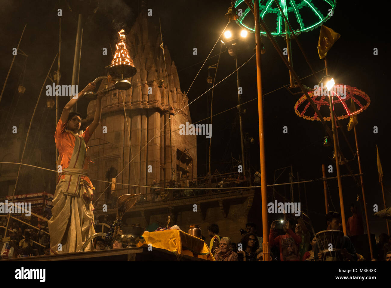 A man holds a lantern aloft a during a nightly ceremony at Dasaswamedh ...