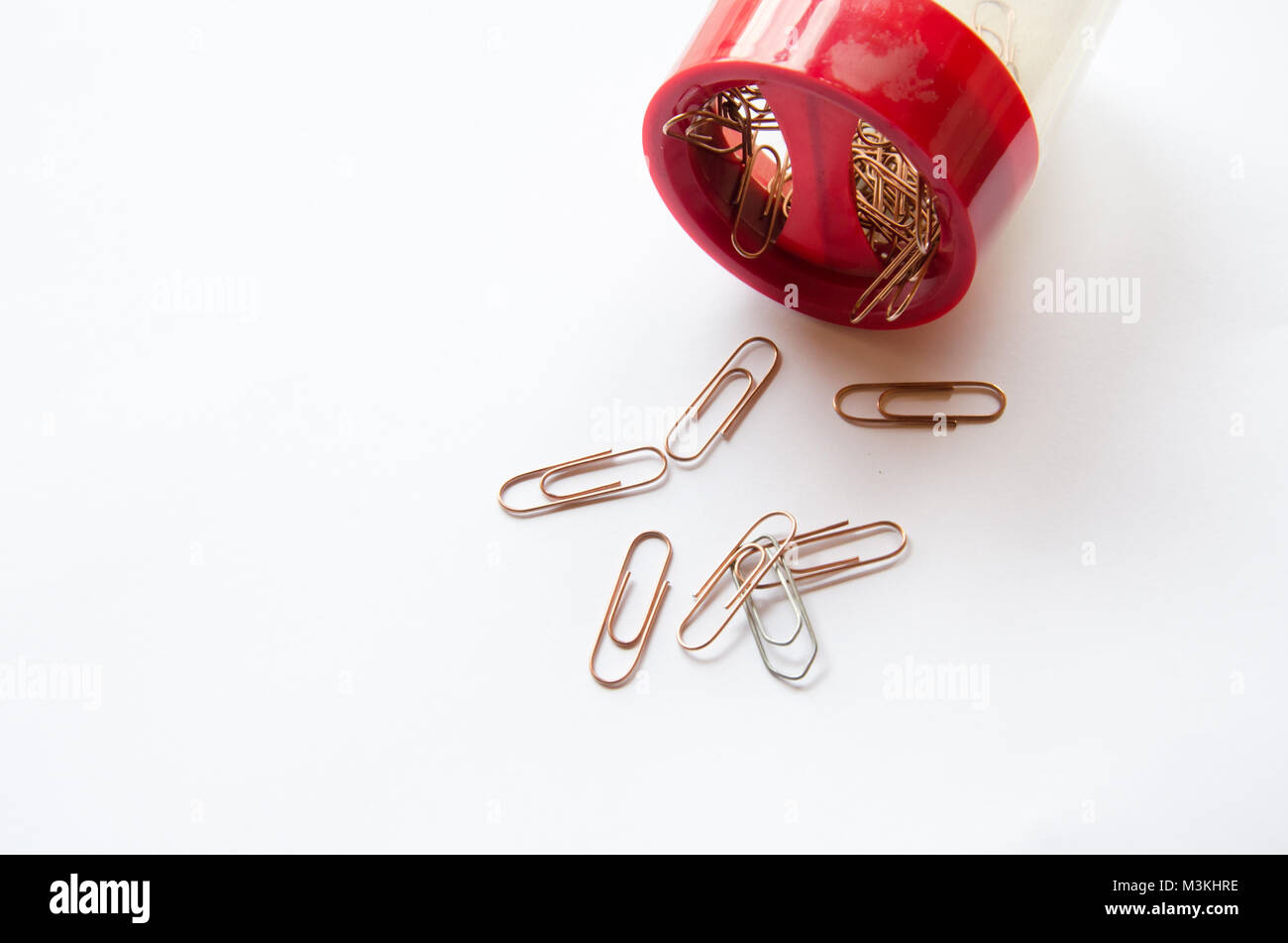Metal paperclips on white background with red plastic holder Stock ...