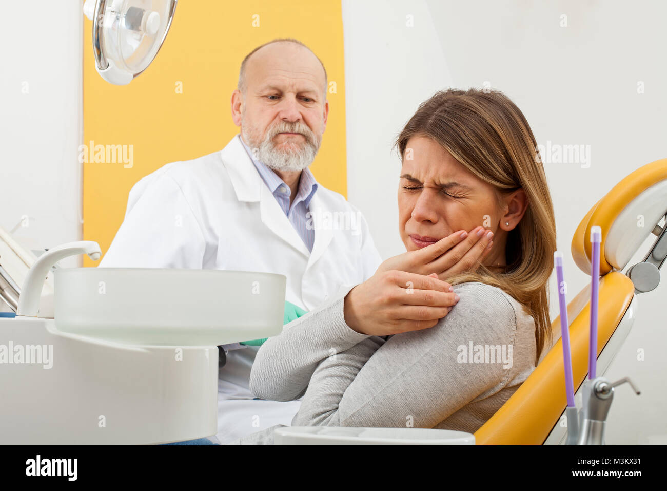 Young female patient with severe toothache at the dentist office with ...