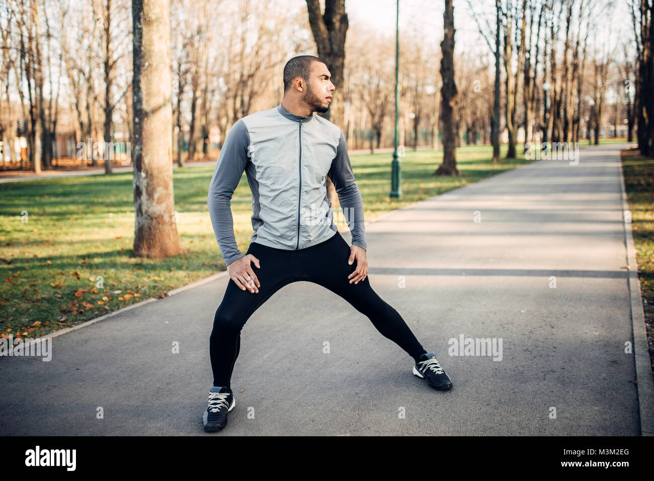 Athlete doing stretching exercise before running. Jogger on morning ...