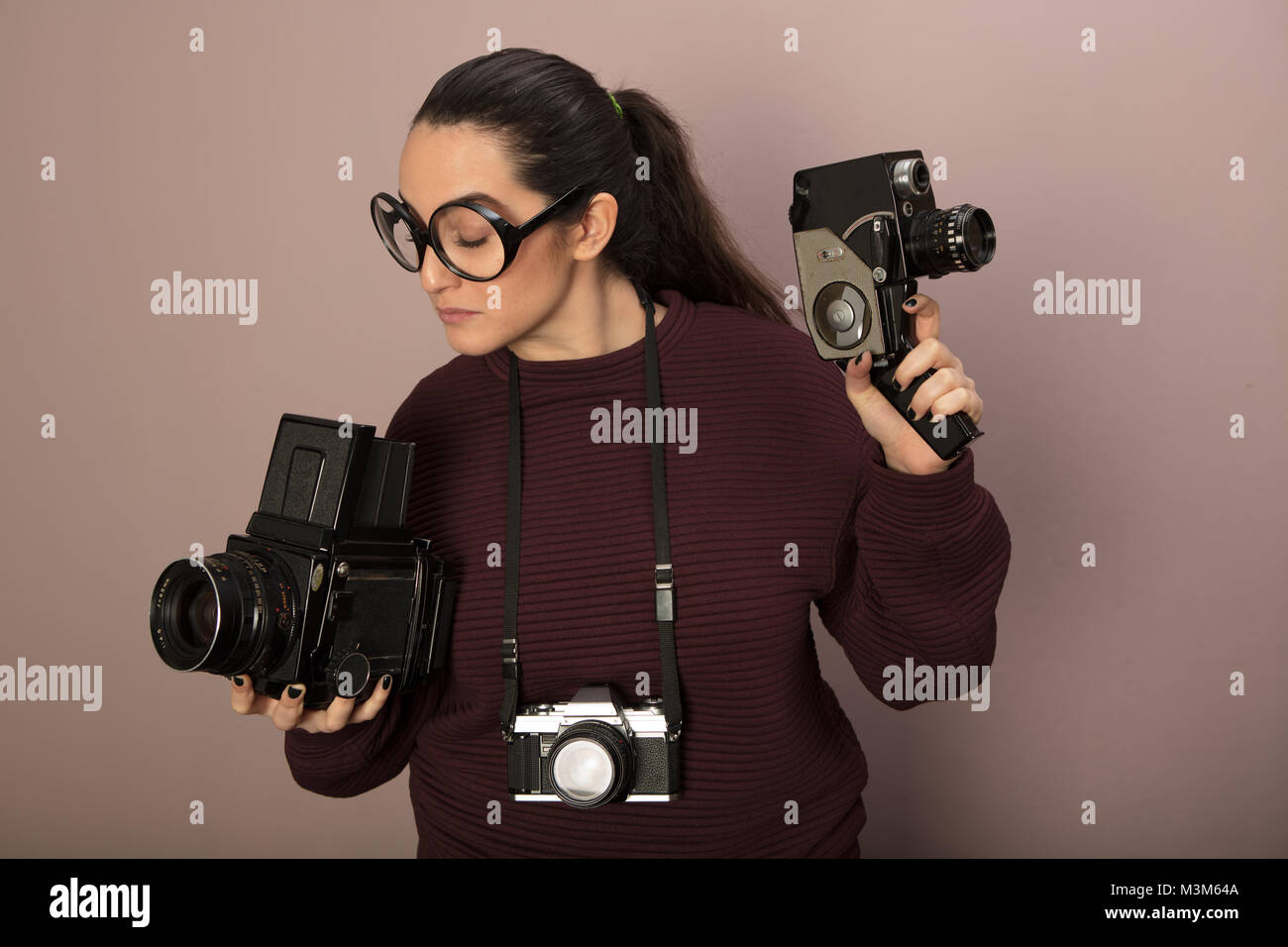 Nerdy young attractive female camera boffin with over size glasses in a ...