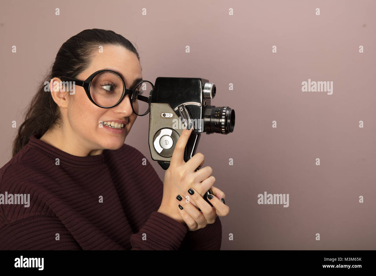 Attractive woman photographer wearing nerdy glasses peering into the ...