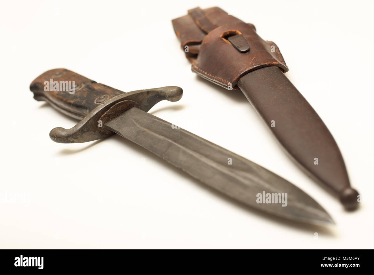 Old dagger with a worn leather sheath to carry the weapon isolated on a ...