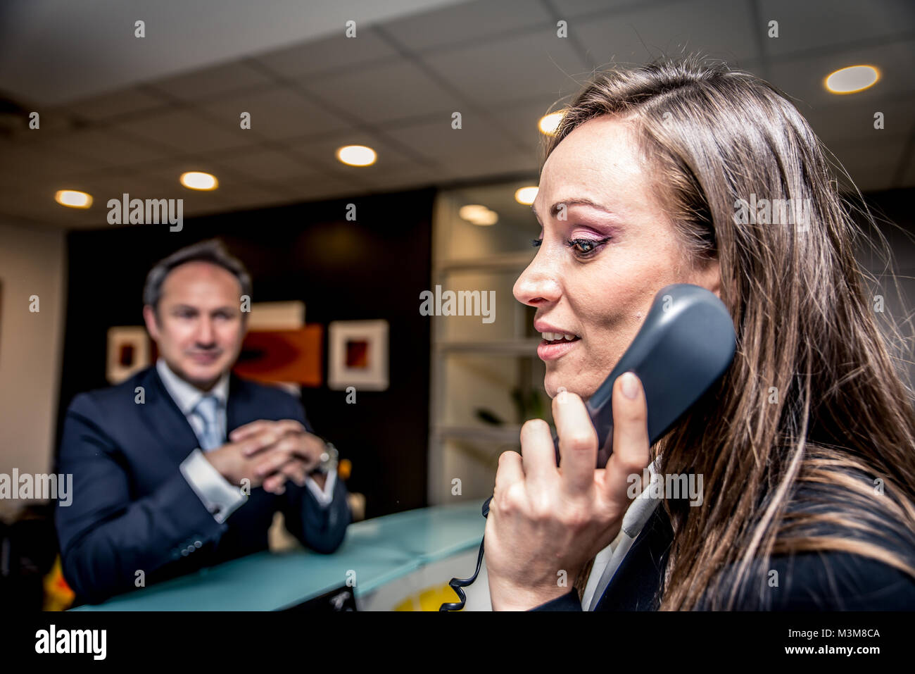 Secretary answering the phone in an office Stock Photo - Alamy
