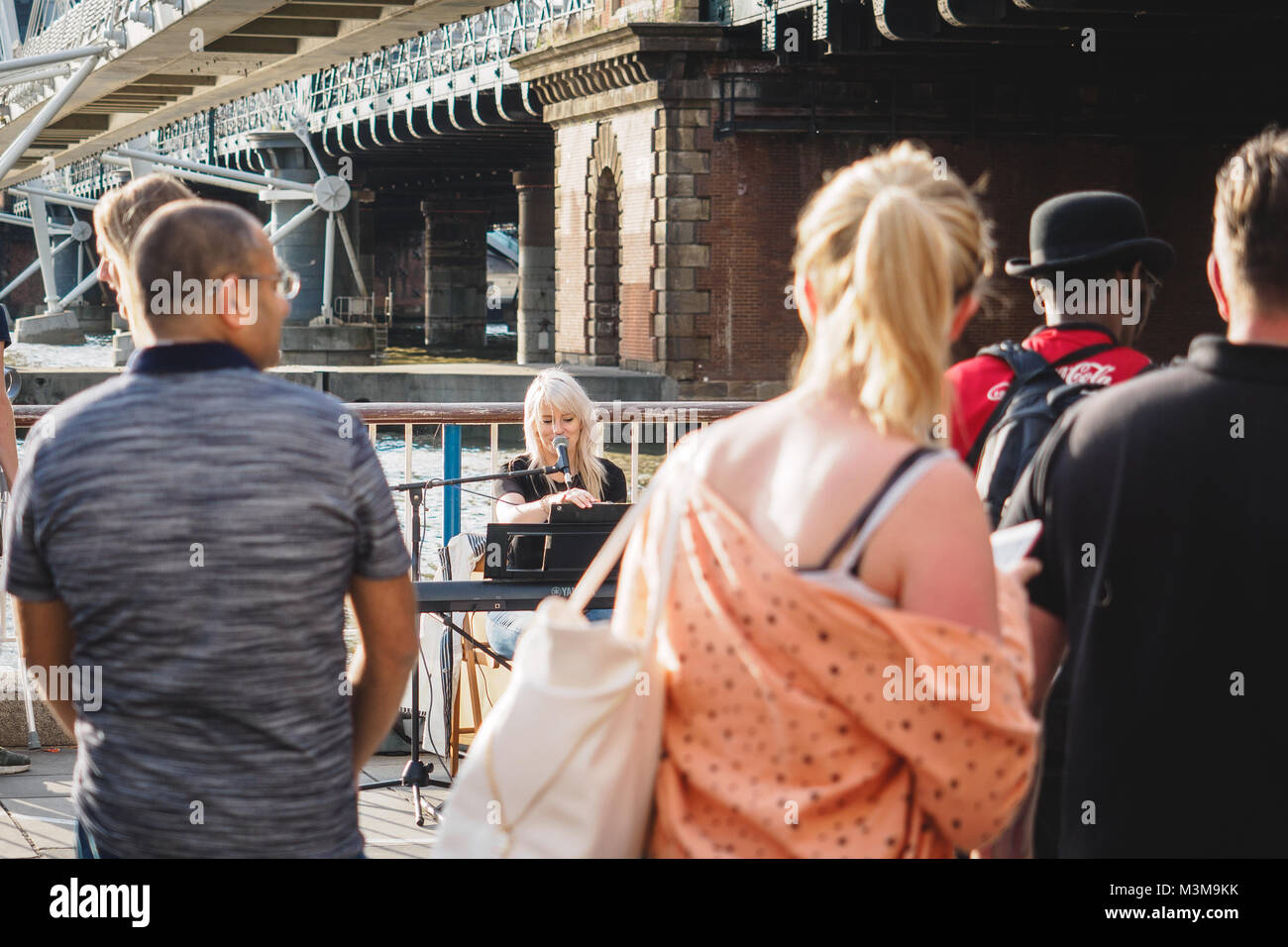 London (UK) - August 2017. People enjoying a street musician and singer ...