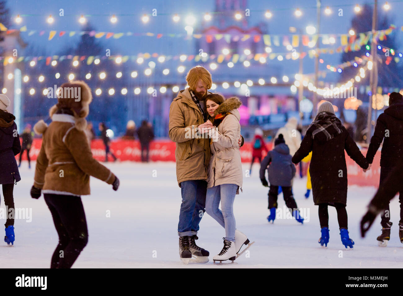 Ice skating rink and lovers together. A pair of young, stylish people ...