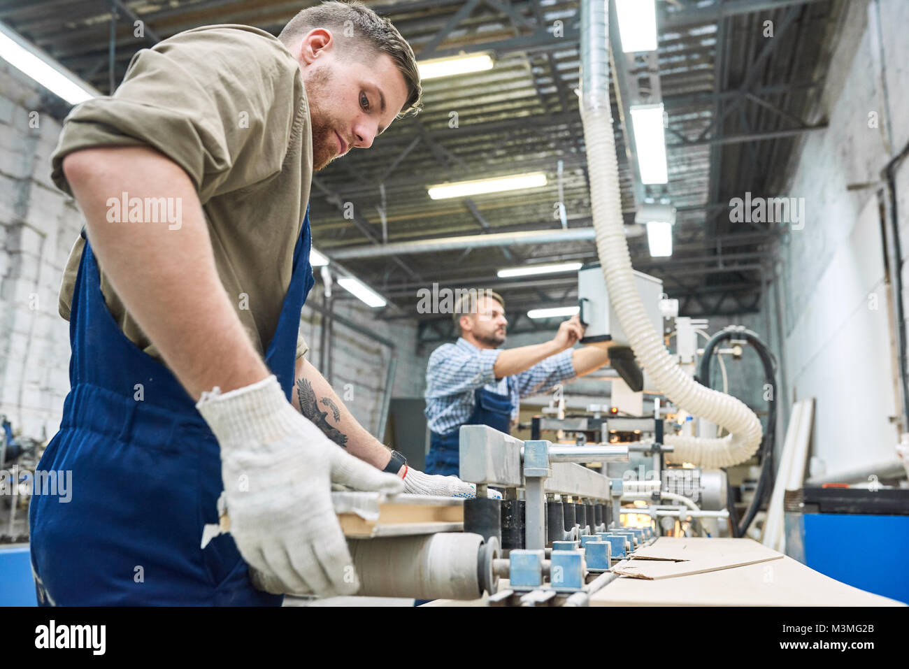 Two Workers Using Machine in Joinery Shop Stock Photo - Alamy