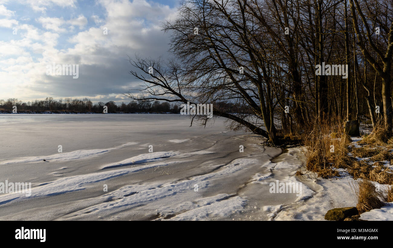 colorful winter sunset on frozen river ice with dramatic clouds and ice ...