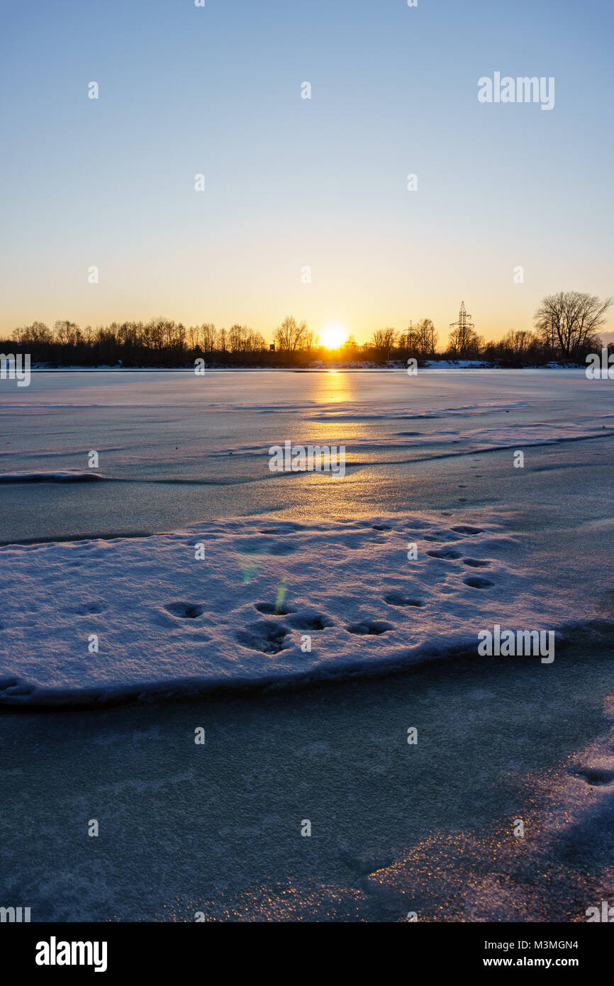 colorful winter sunset on frozen river ice with dramatic clouds Stock ...