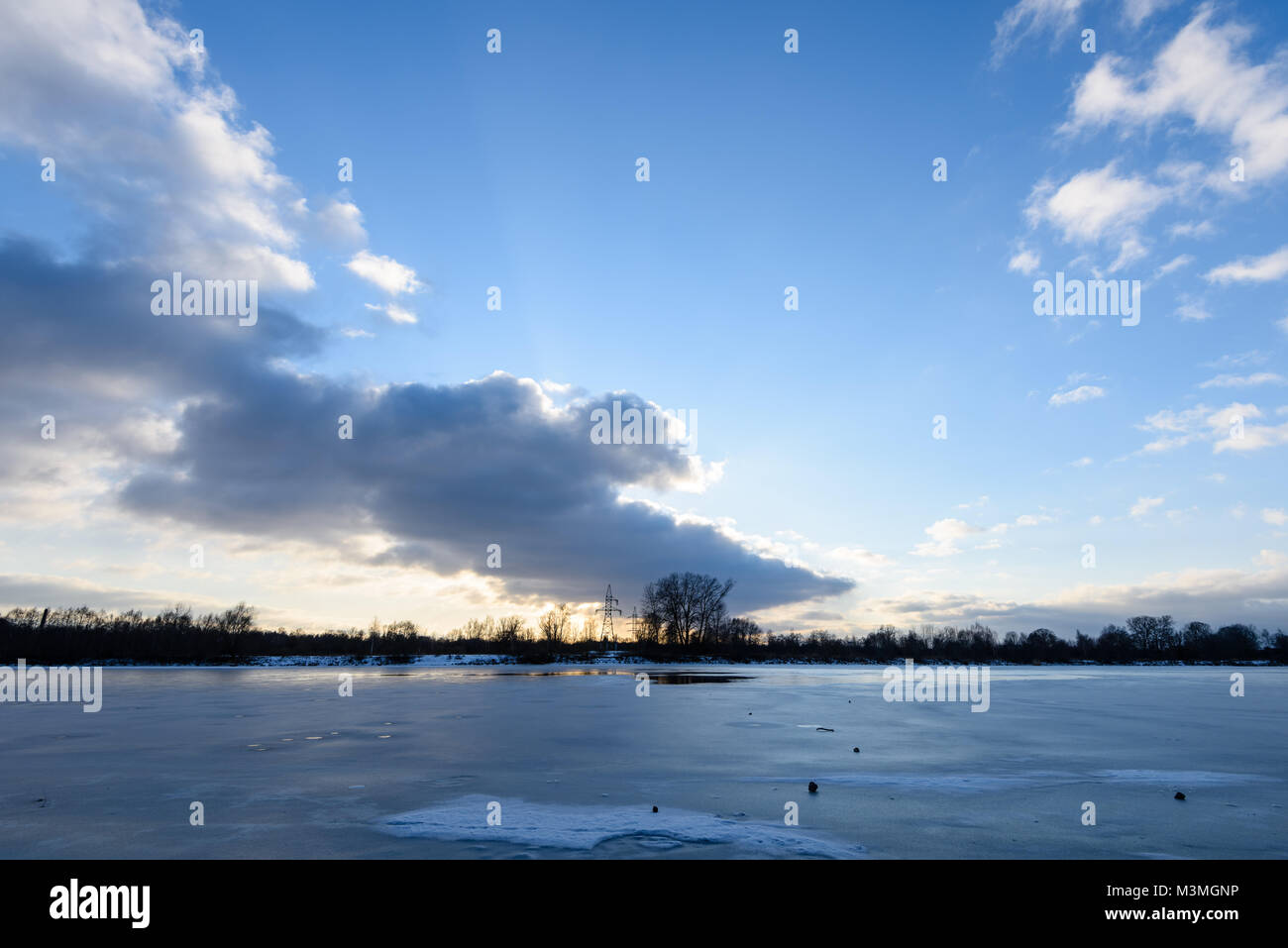 colorful winter sunset on frozen river ice with dramatic clouds and ice ...