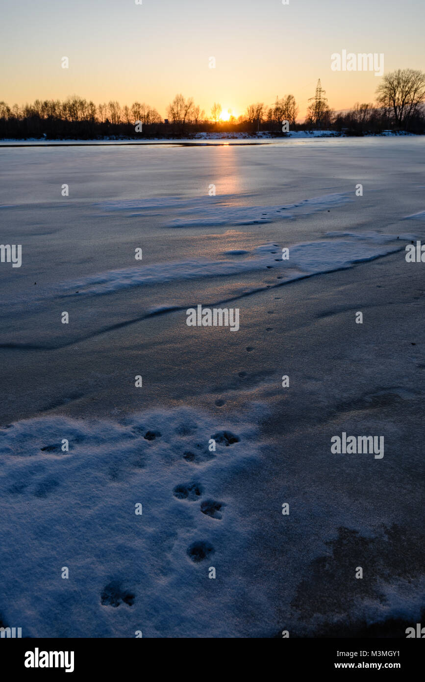 colorful winter sunset on frozen river ice with dramatic clouds Stock ...