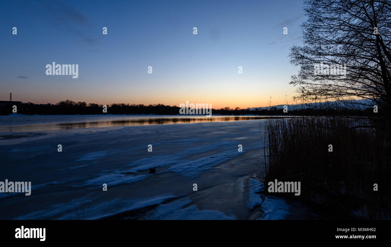 colorful winter sunset on frozen river ice with dramatic clouds Stock ...