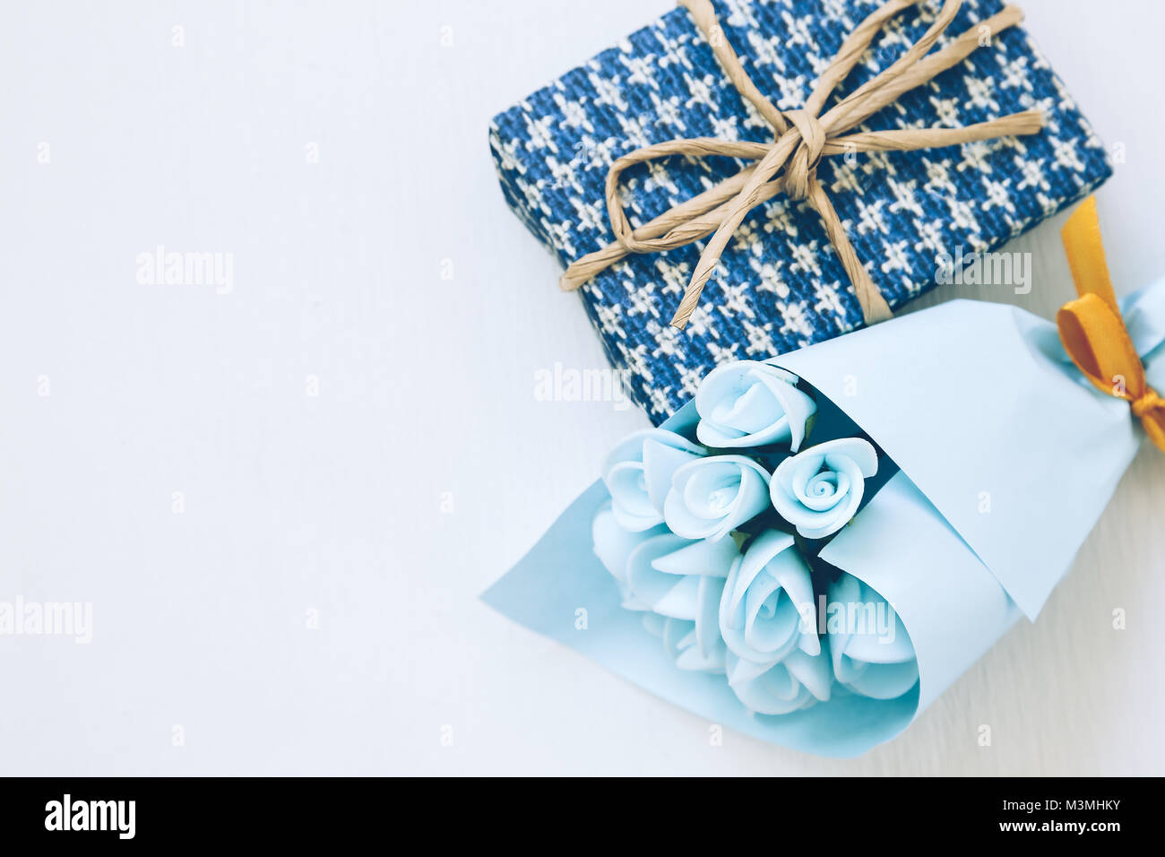 Gift and blue flower bouquet on white background Stock Photo - Alamy