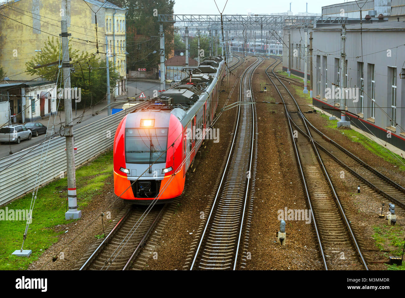 Modern electric locomotive pulling a high-speed train on rails ...