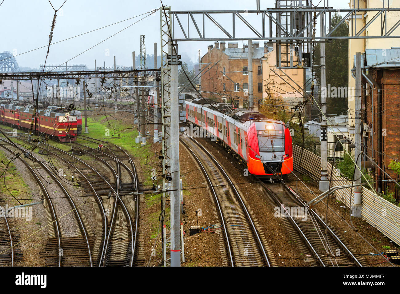 Modern electric locomotive pulling a high-speed train on rails ...