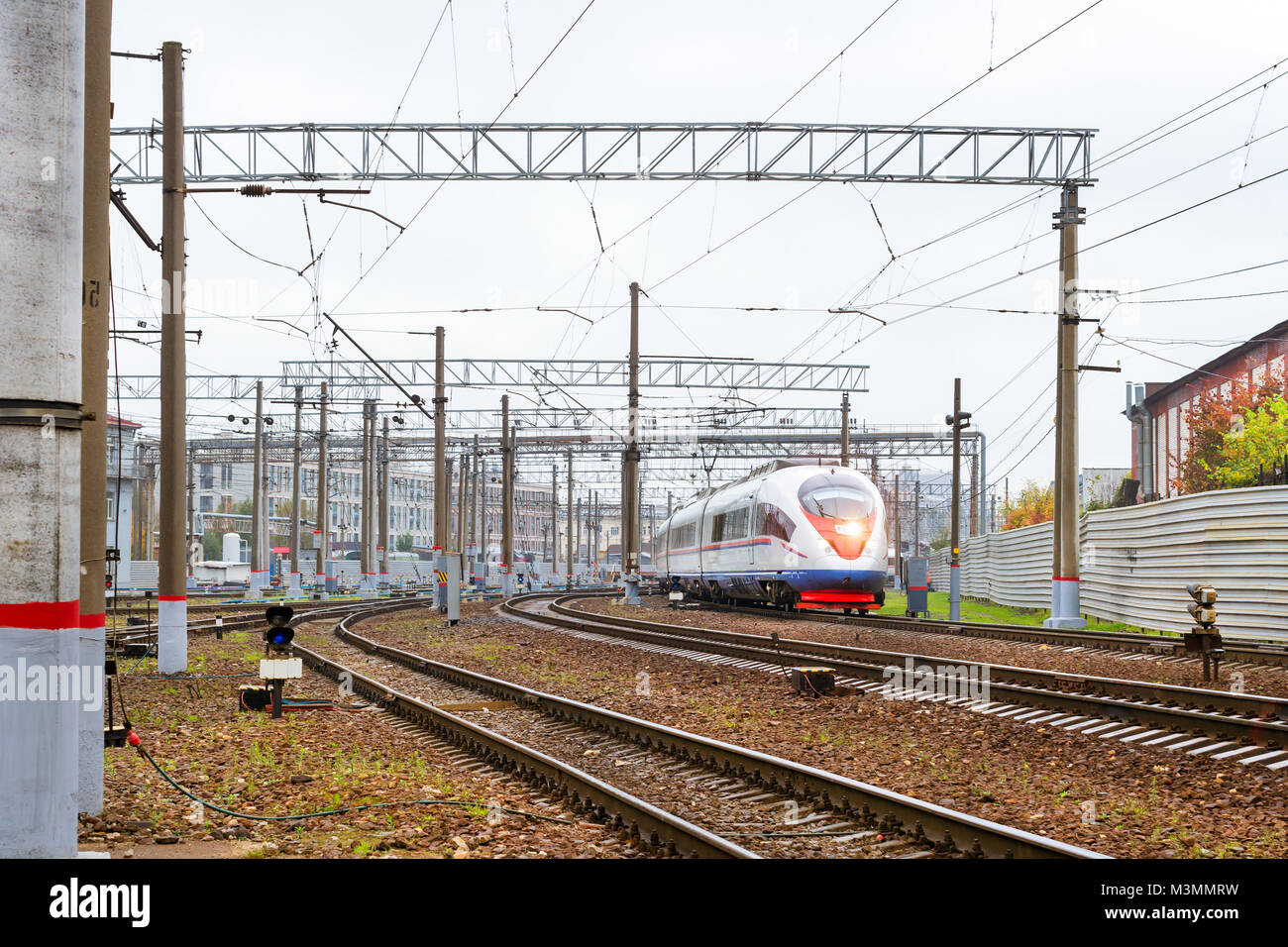 Modern hybrid electric locomotive pulling a high-speed train on rails ...