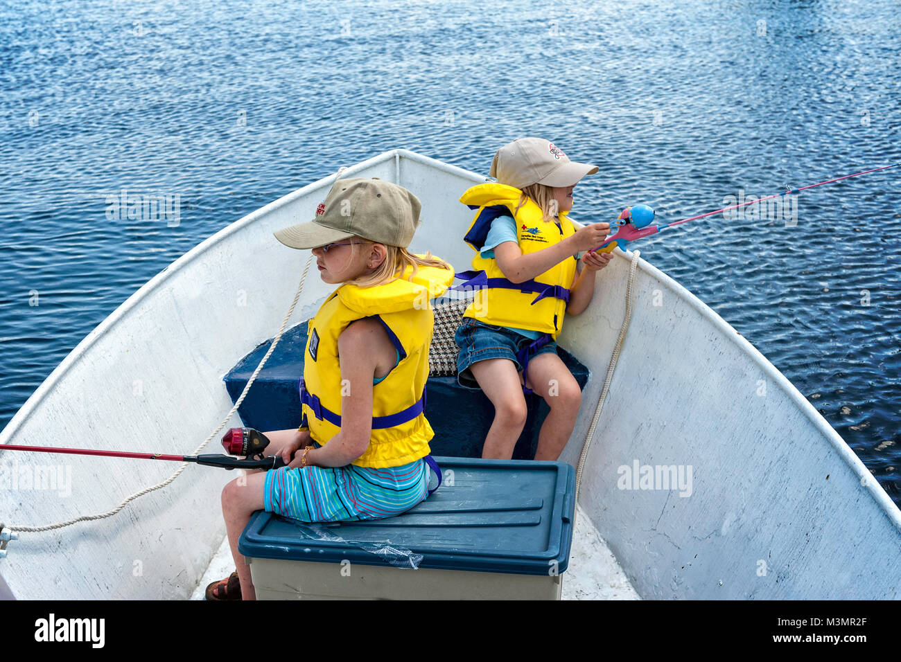 Two little girls fishing from a boat Stock Photo - Alamy