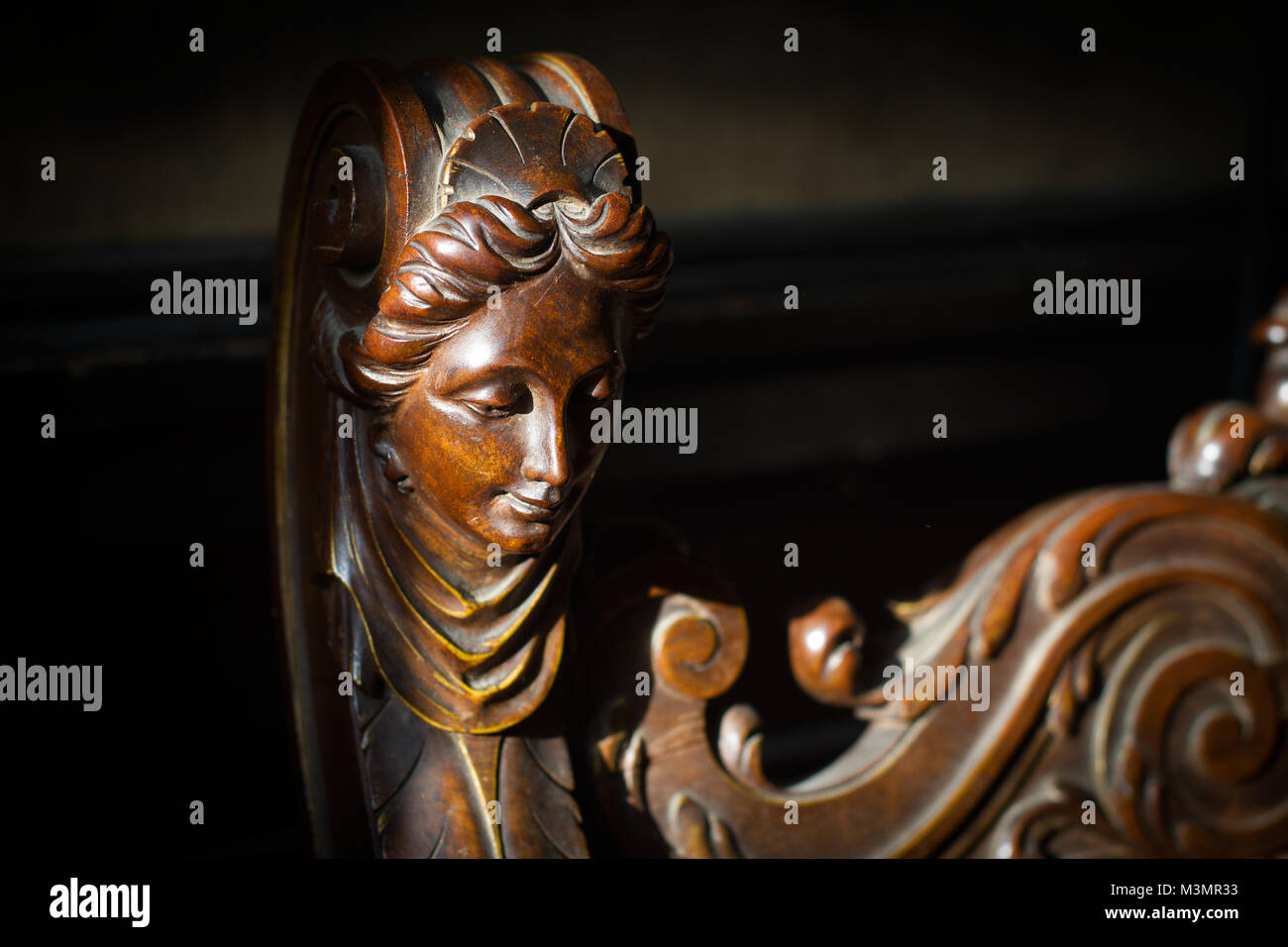 side view closeup detail of antique wooden young woman figurine ...