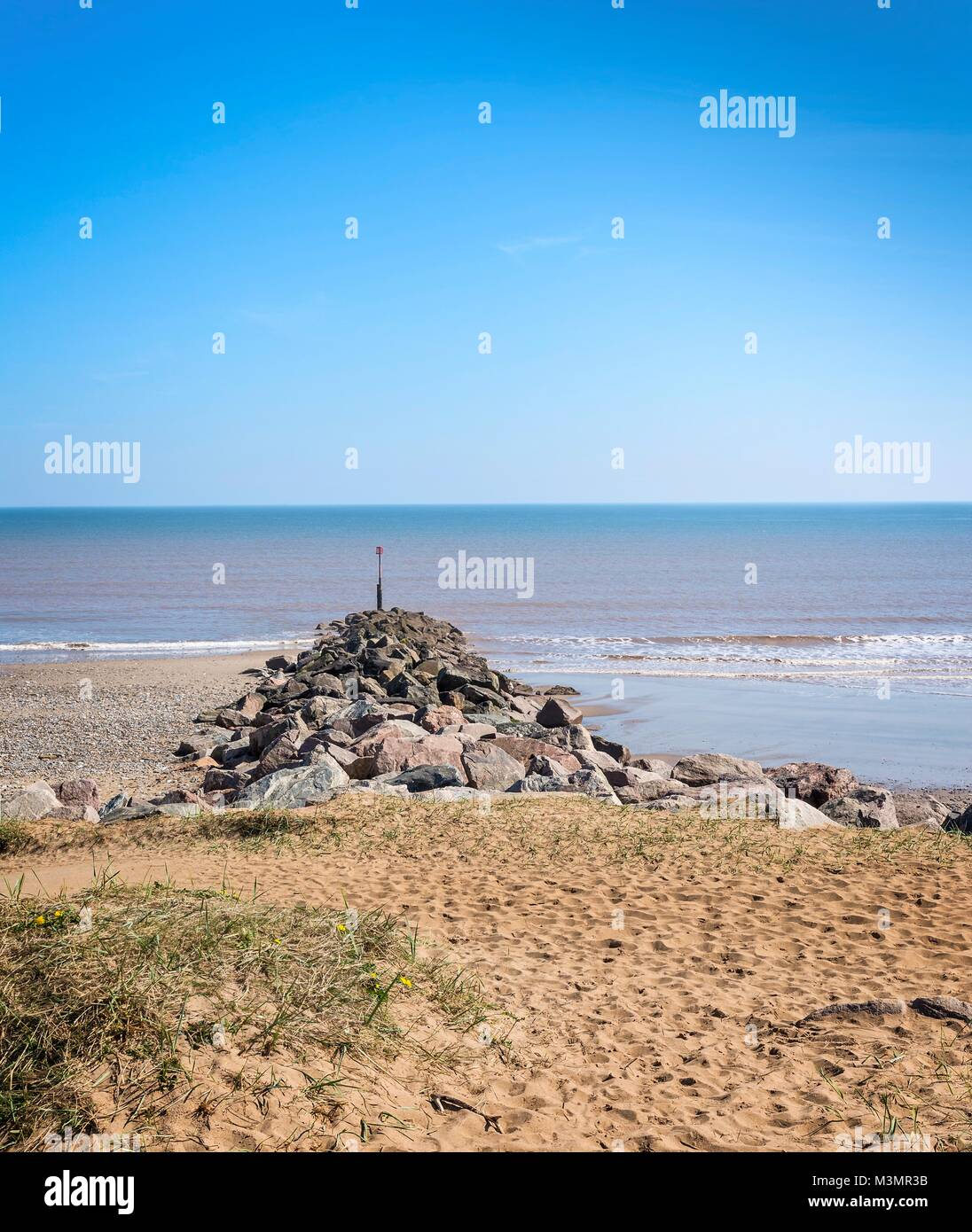 Send dune leading to a rock groyne. The sea is under a blue sky Stock ...