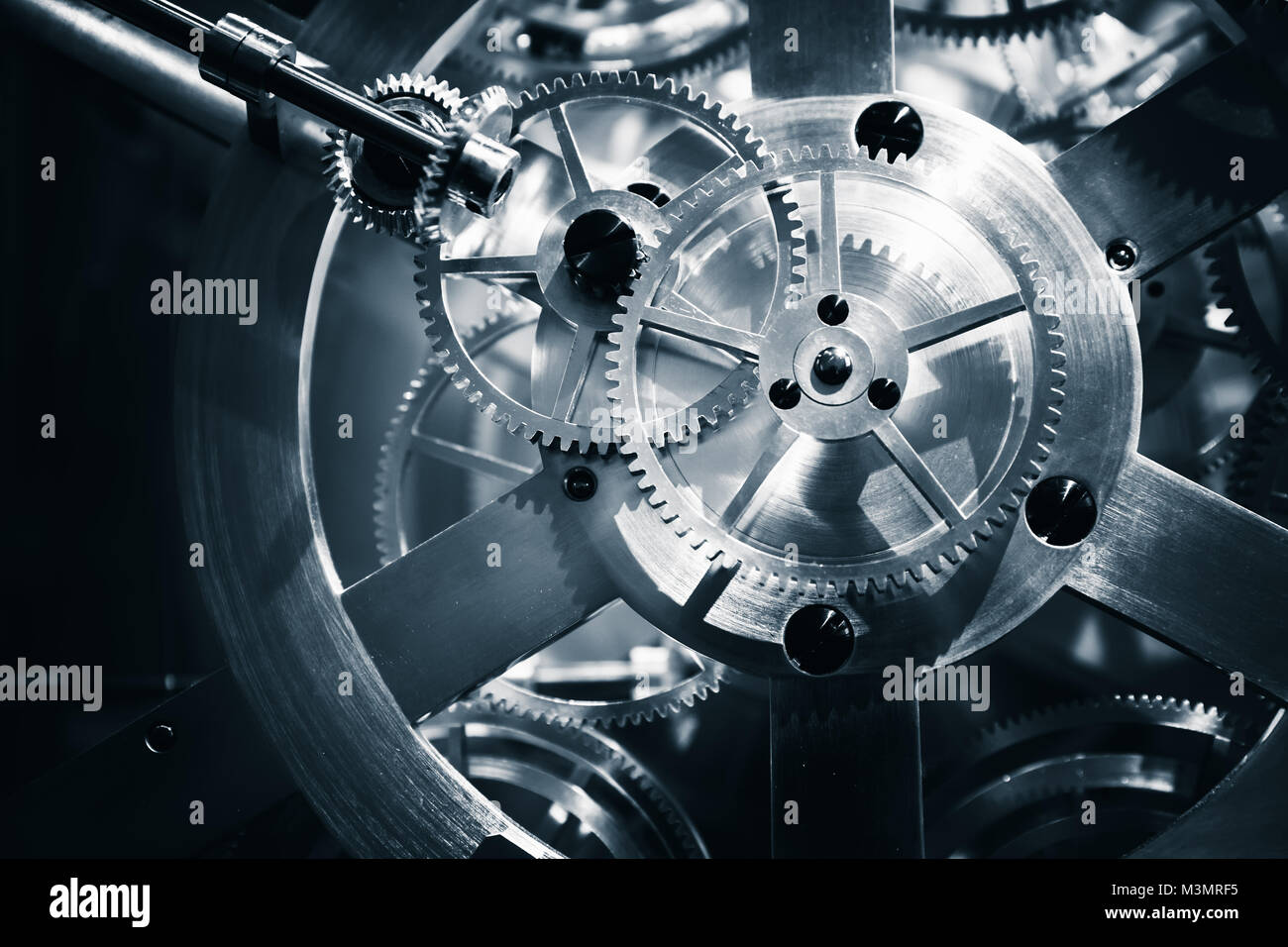 Vintage clock mechanism, close-up fragment with shiny gears, blue toned ...