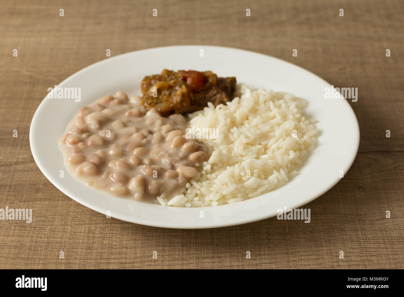 Meal with white rice, pinto beans and meat with sauce. White dish on ...