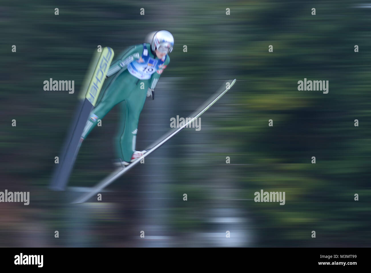 Ski jumper soars with speed in motion blur trough the air. Jumping Hill ...