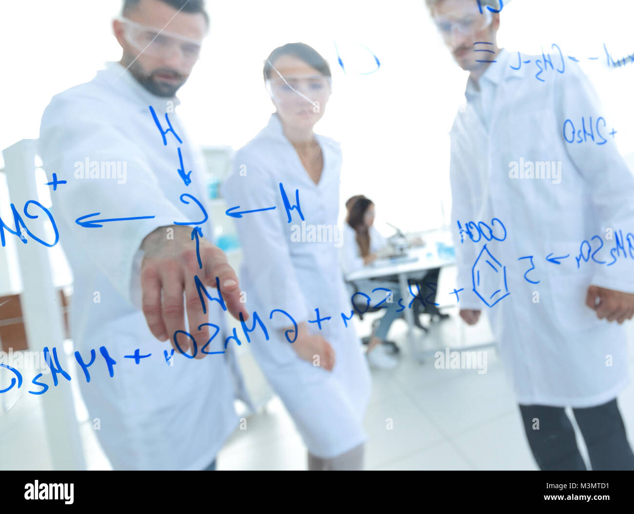 group of laboratory scientists discussing their research in the ...