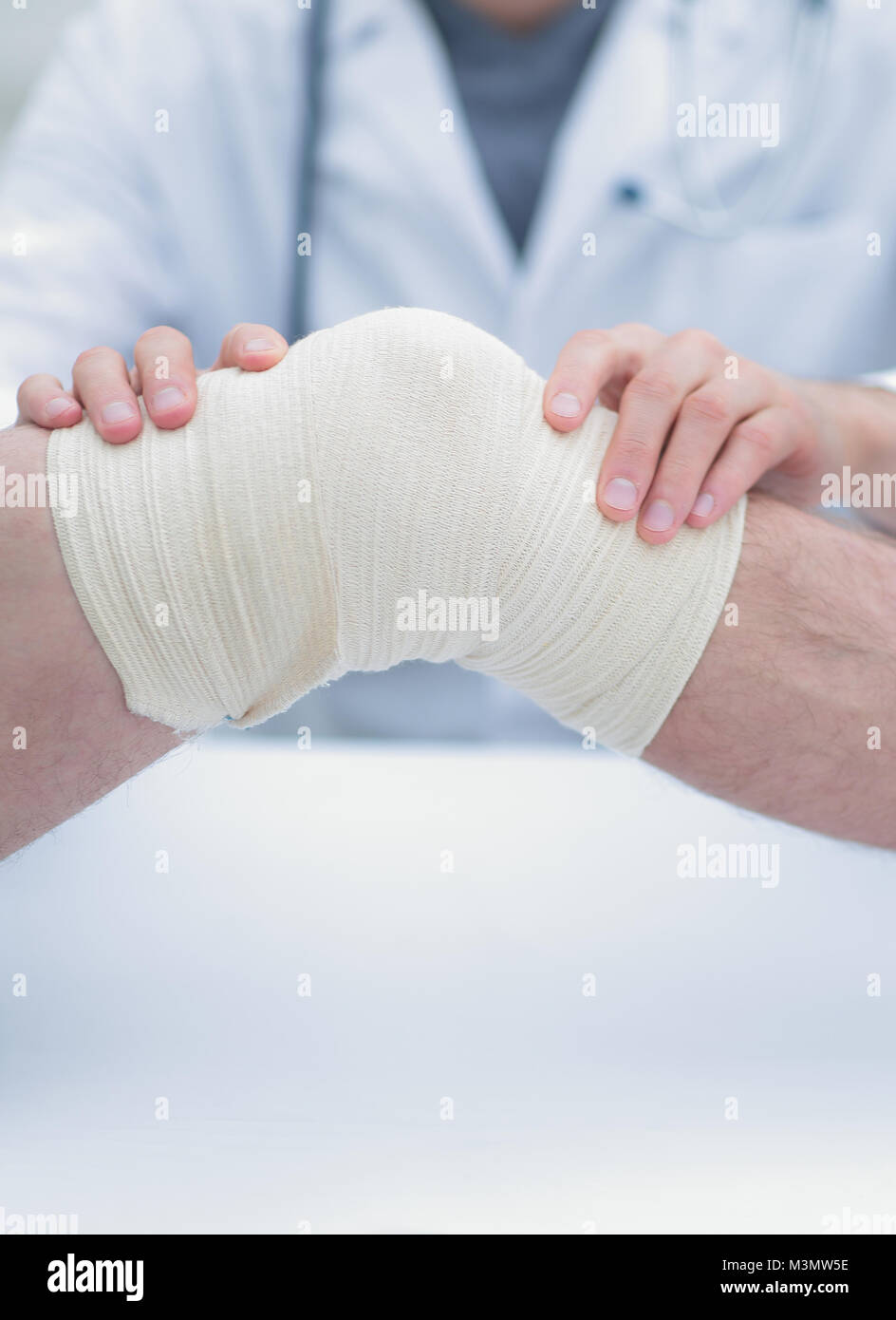 traumatologist ,applying a bandage on the knee Stock Photo - Alamy